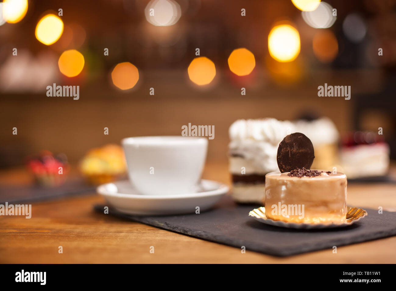 Fresh chocholate cake with sweet biscuit on top in a coffee shop. Sweet ...