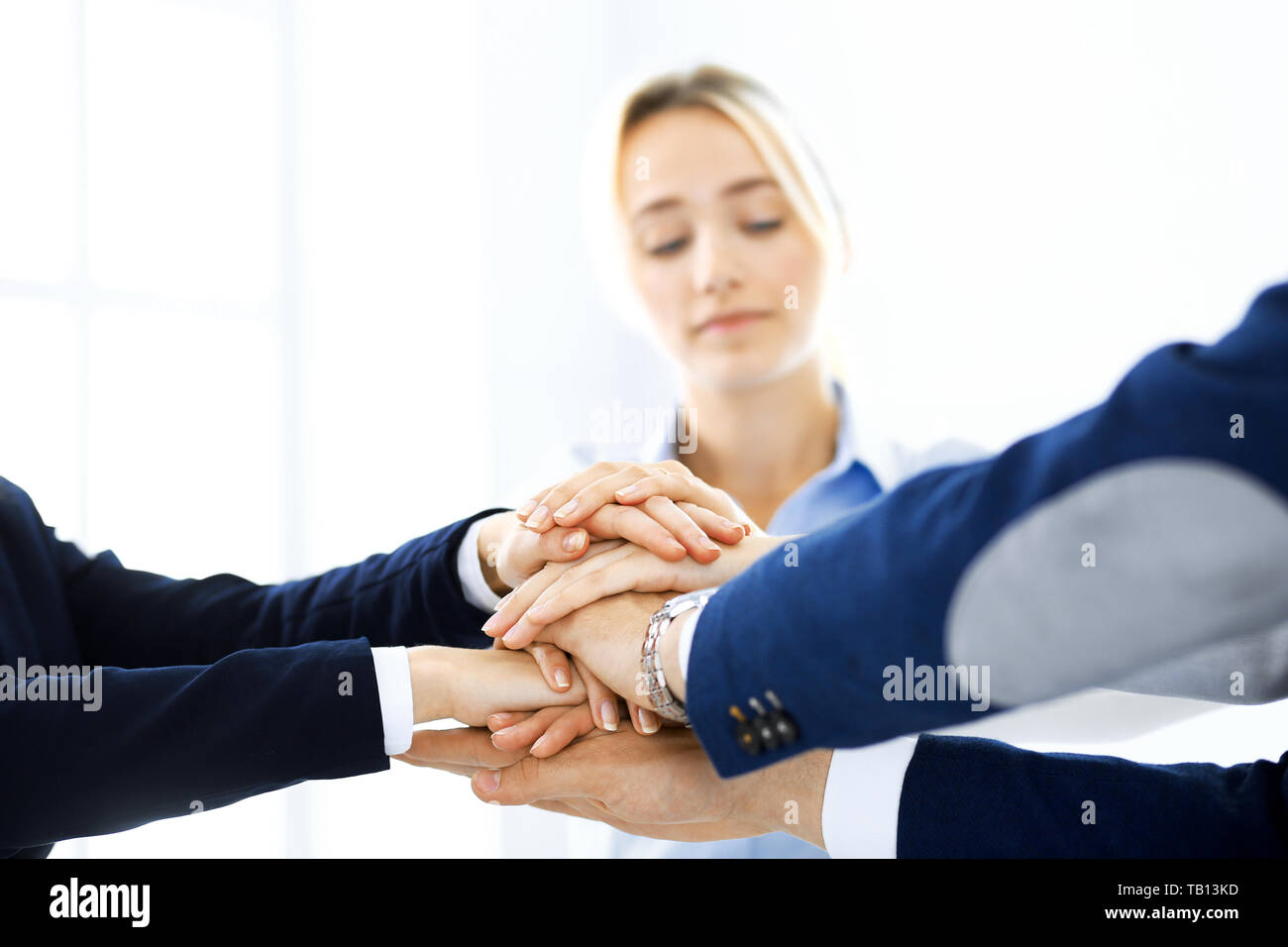Business team showing unity with their hands together. Group of people joining hands and ...