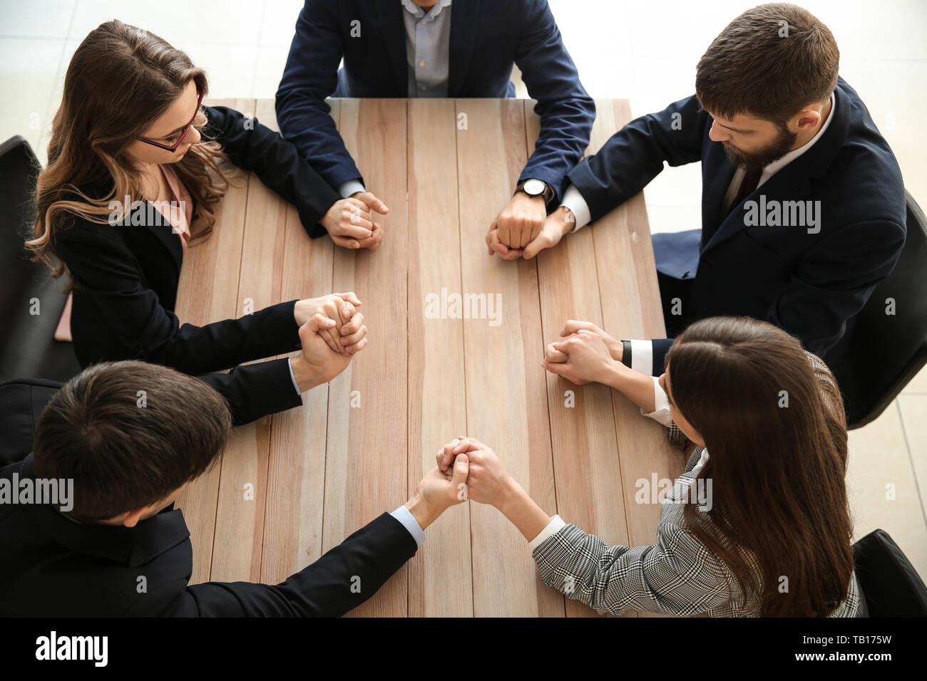 Group of people praying before meeting in office Stock Photo - Alamy