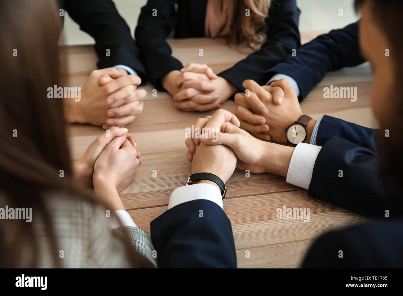 Group of people praying before meeting in office Stock Photo - Alamy