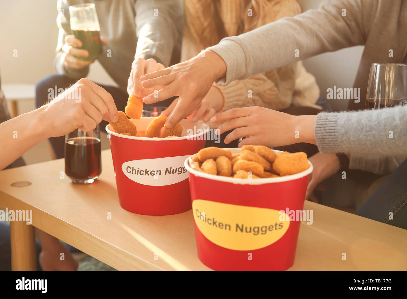 Group of friends eating nuggets at home Stock Photo - Alamy