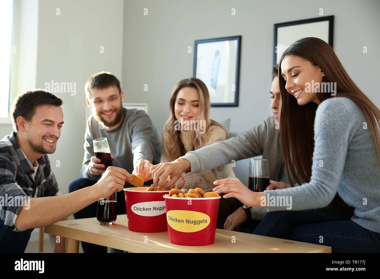 Group of friends eating nuggets at home Stock Photo - Alamy