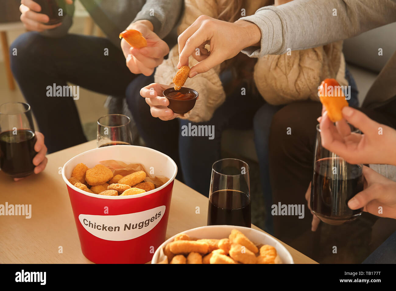 Group of friends eating nuggets at home Stock Photo - Alamy