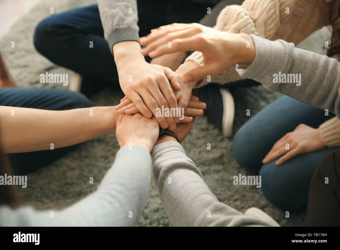 Group of people putting hands together at home Stock Photo - Alamy