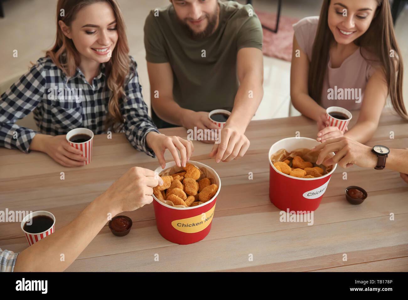 Group of friends eating nuggets at home Stock Photo - Alamy