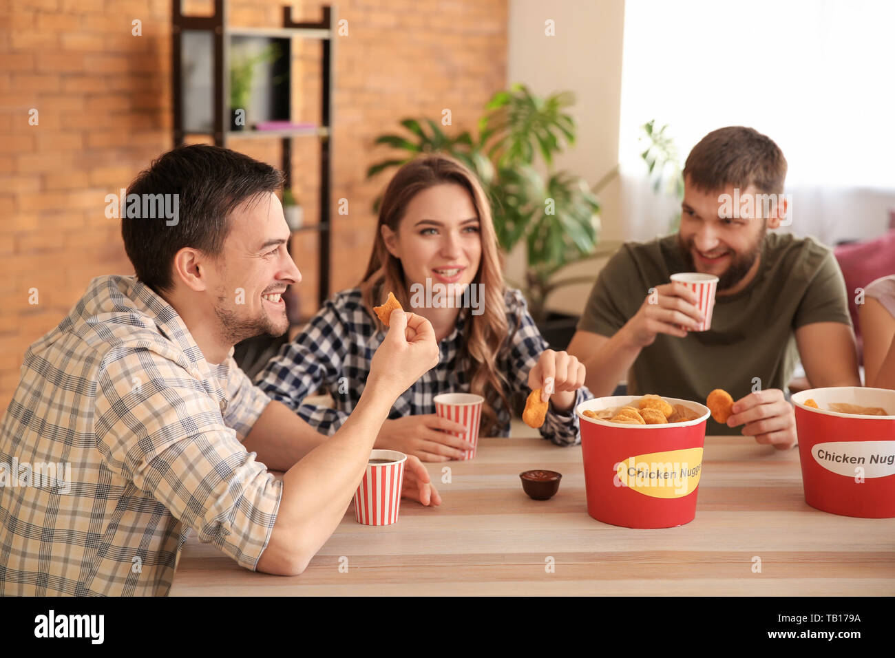 Group of friends eating nuggets at home Stock Photo - Alamy
