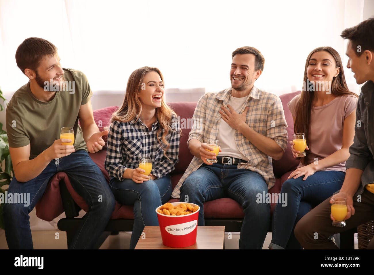 Group of friends eating nuggets at home Stock Photo - Alamy
