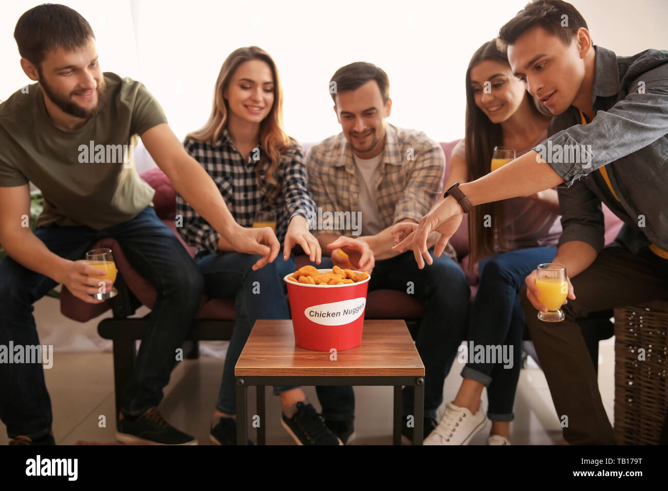Group of friends eating nuggets at home Stock Photo - Alamy
