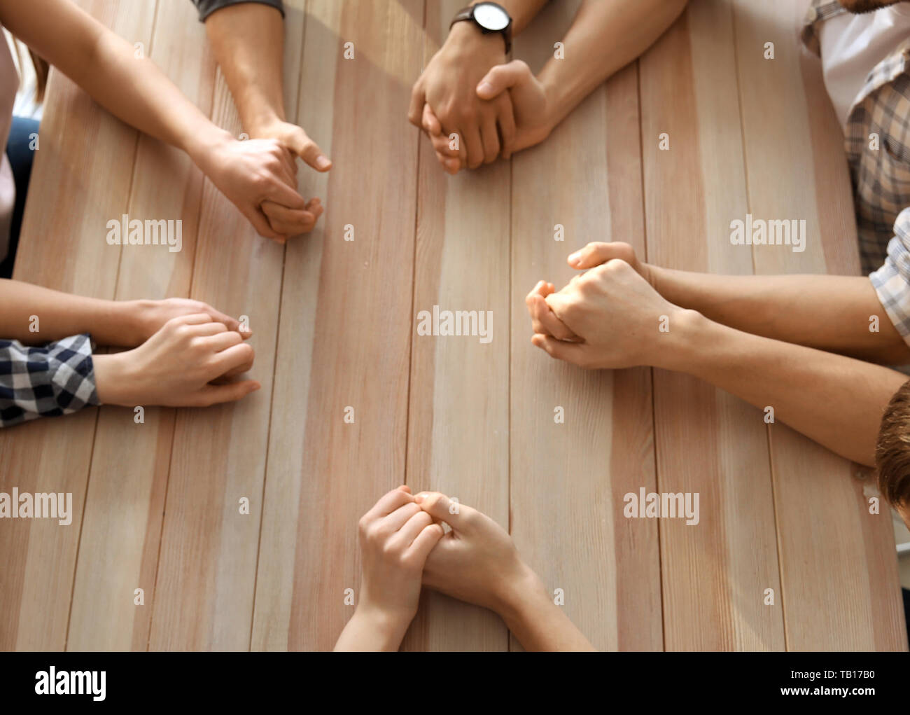 Group of people praying at table Stock Photo - Alamy