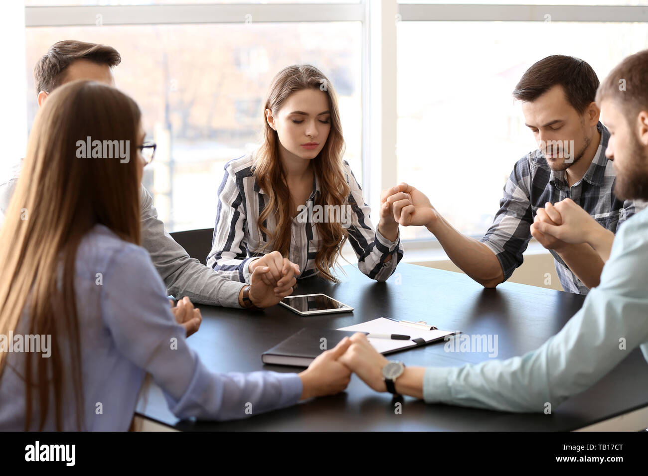 Group of people praying before meeting in office Stock Photo - Alamy