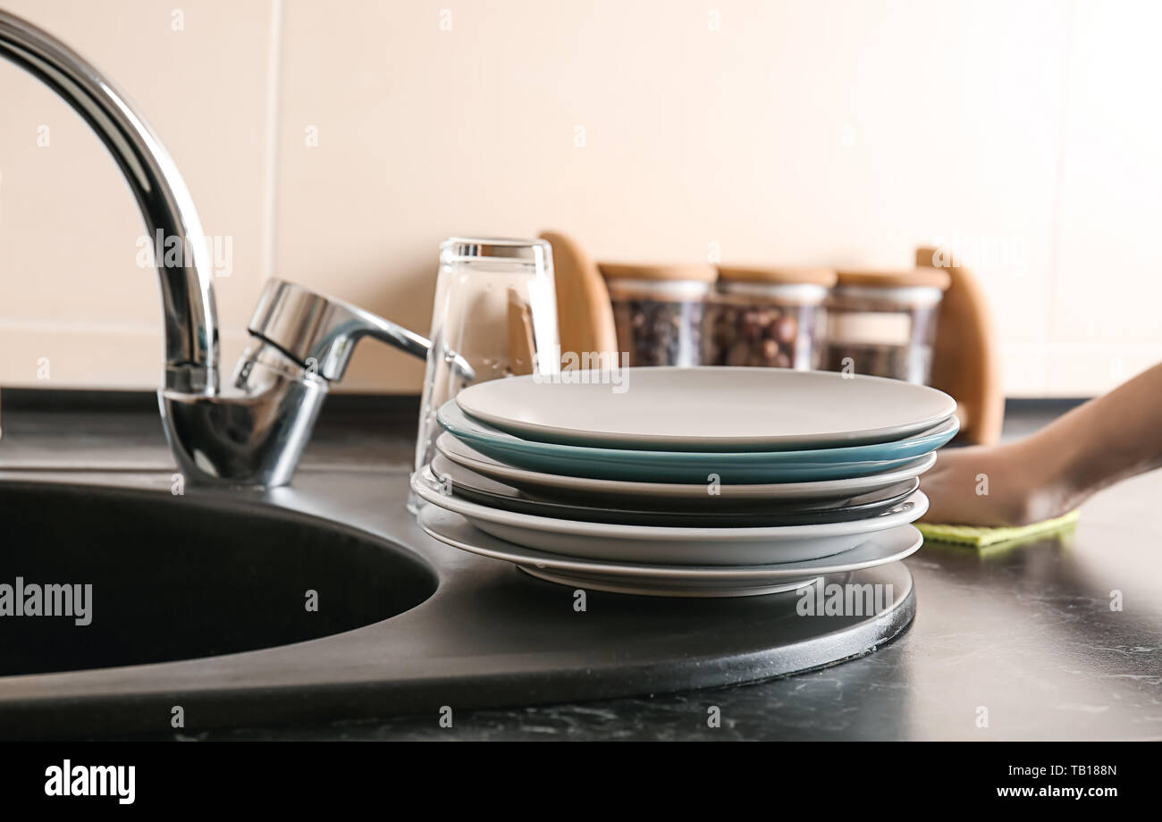 Stack of clean plates near kitchen sink Stock Photo - Alamy
