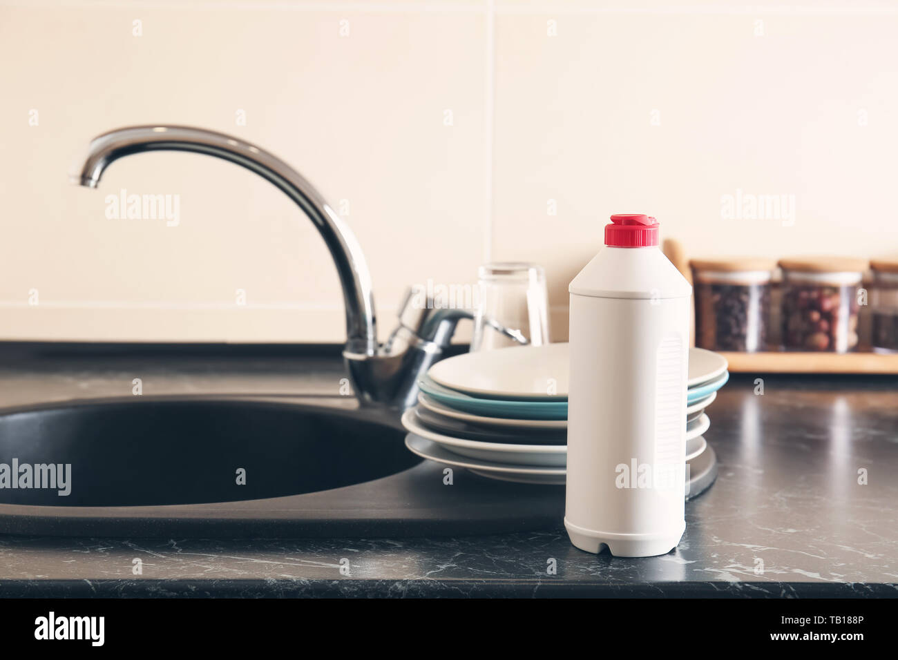 Stack of clean plates and bottle of detergent near kitchen sink Stock ...