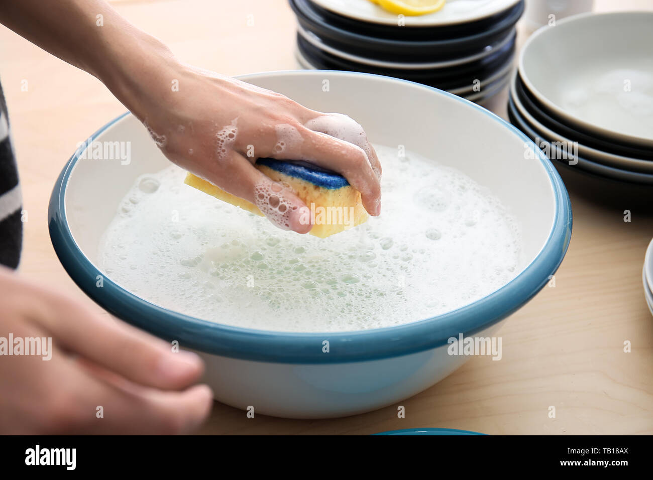 Woman washing plate in kitchen Stock Photo - Alamy