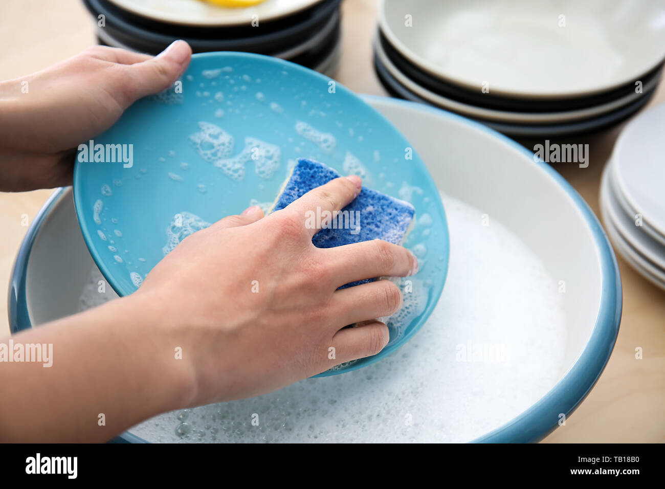 Woman washing plate in kitchen Stock Photo - Alamy