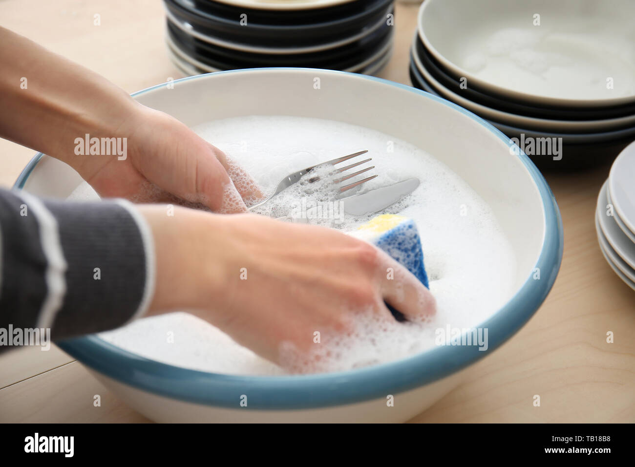 Woman washing cutlery in kitchen Stock Photo - Alamy