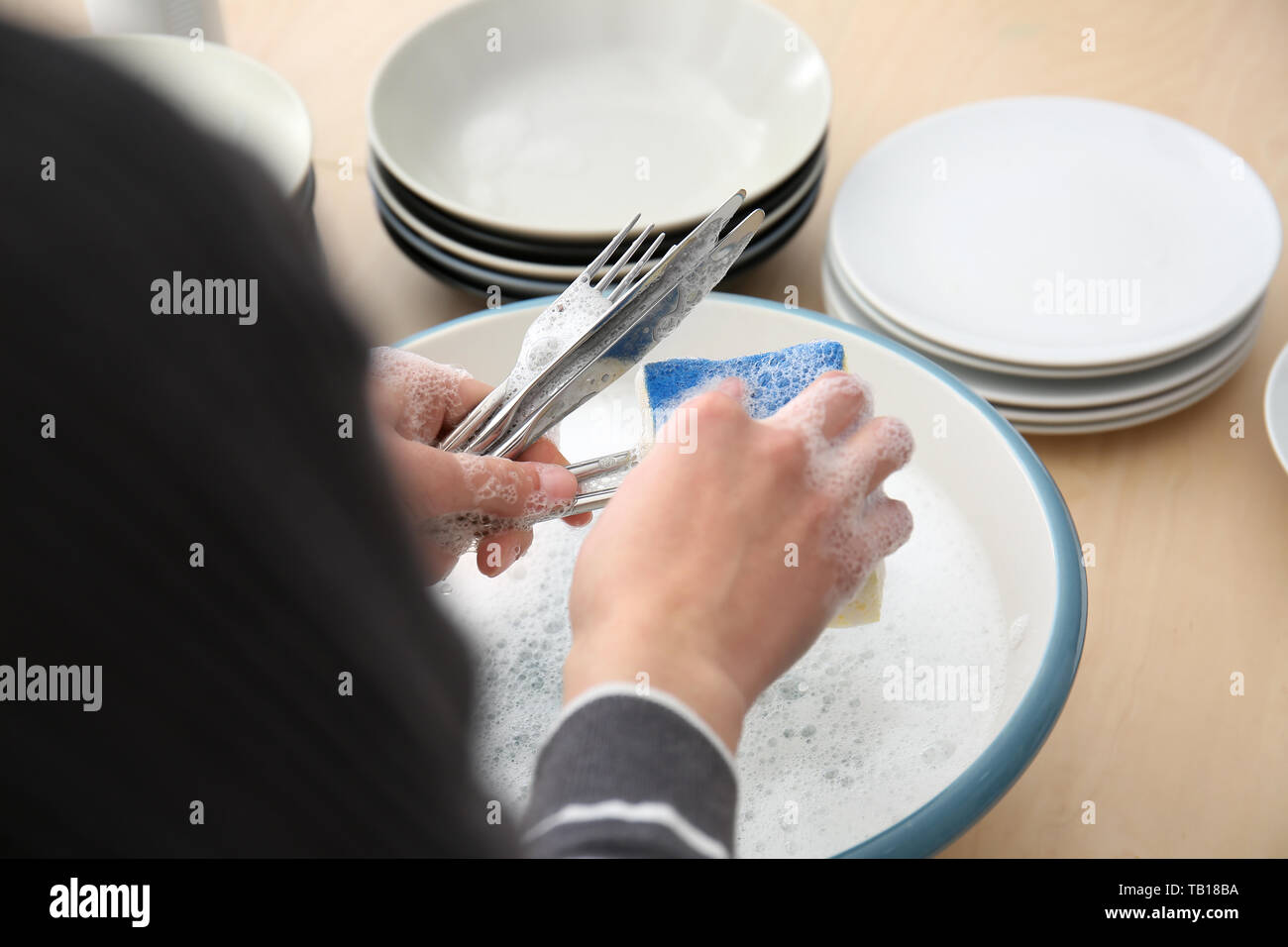 Woman washing cutlery in kitchen Stock Photo - Alamy