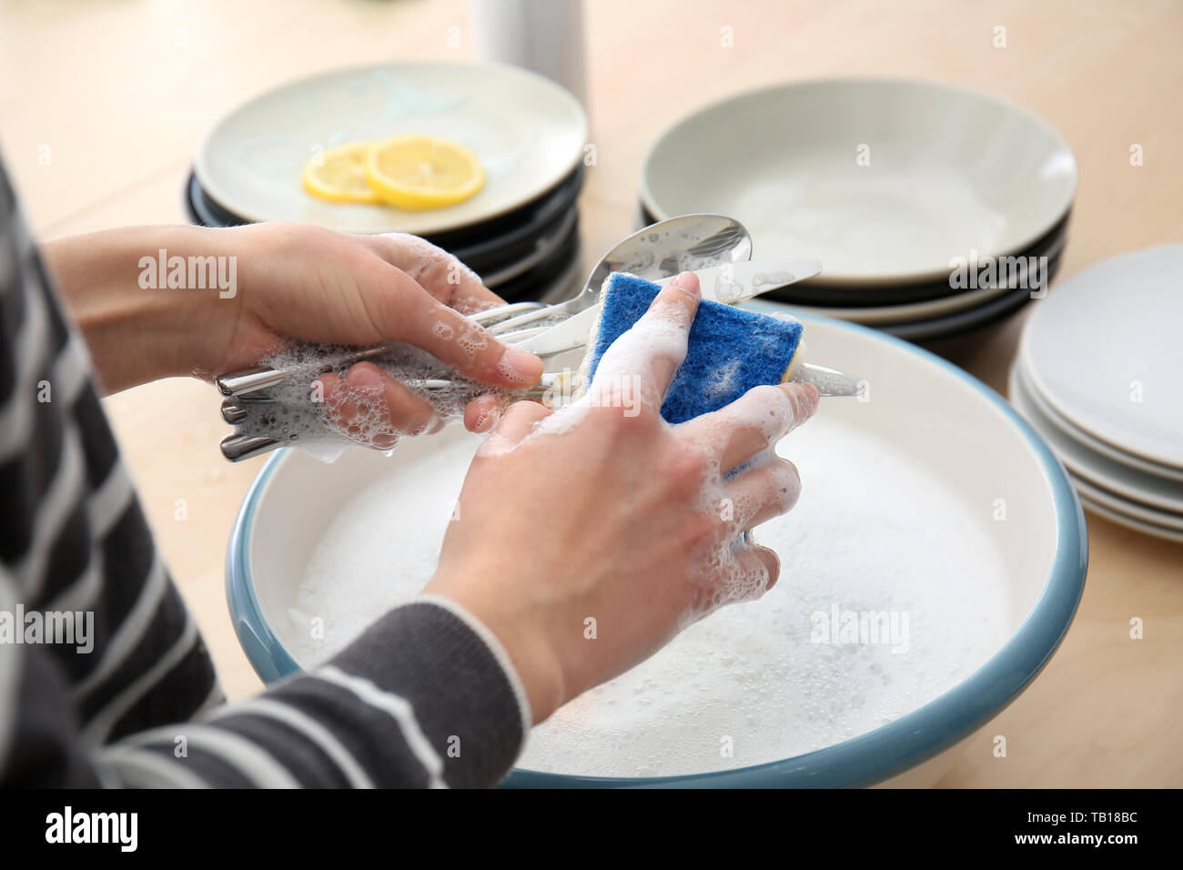 Woman washing cutlery in kitchen Stock Photo - Alamy