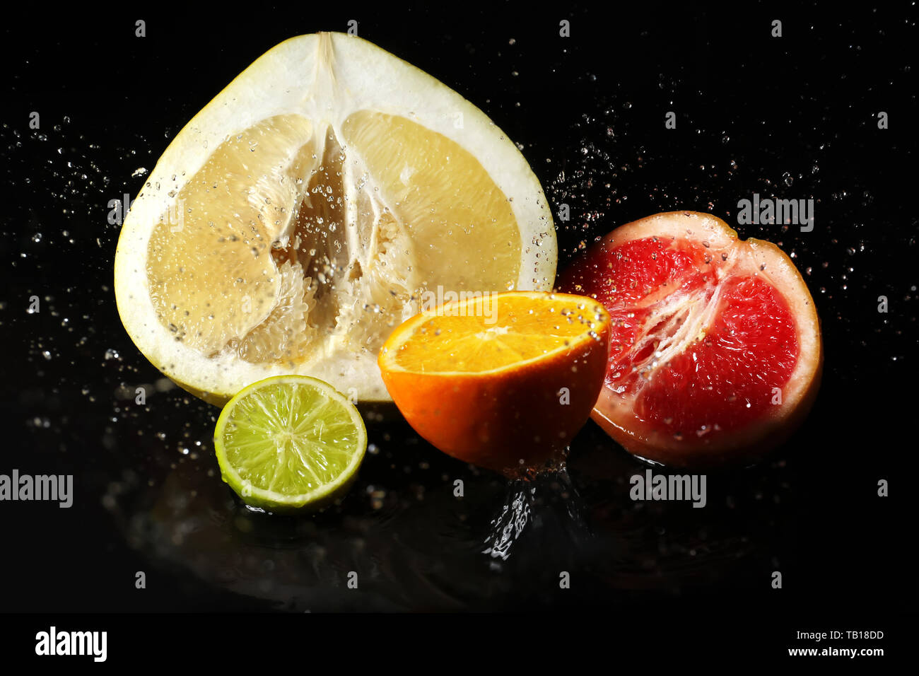 Ripe cut fruits with water splash on dark background Stock Photo - Alamy
