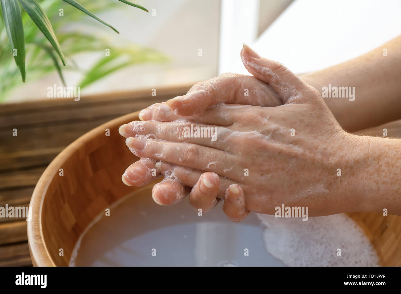 Woman washing hands in bowl Stock Photo - Alamy