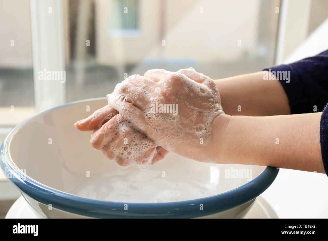 Woman washing hands in bowl Stock Photo - Alamy