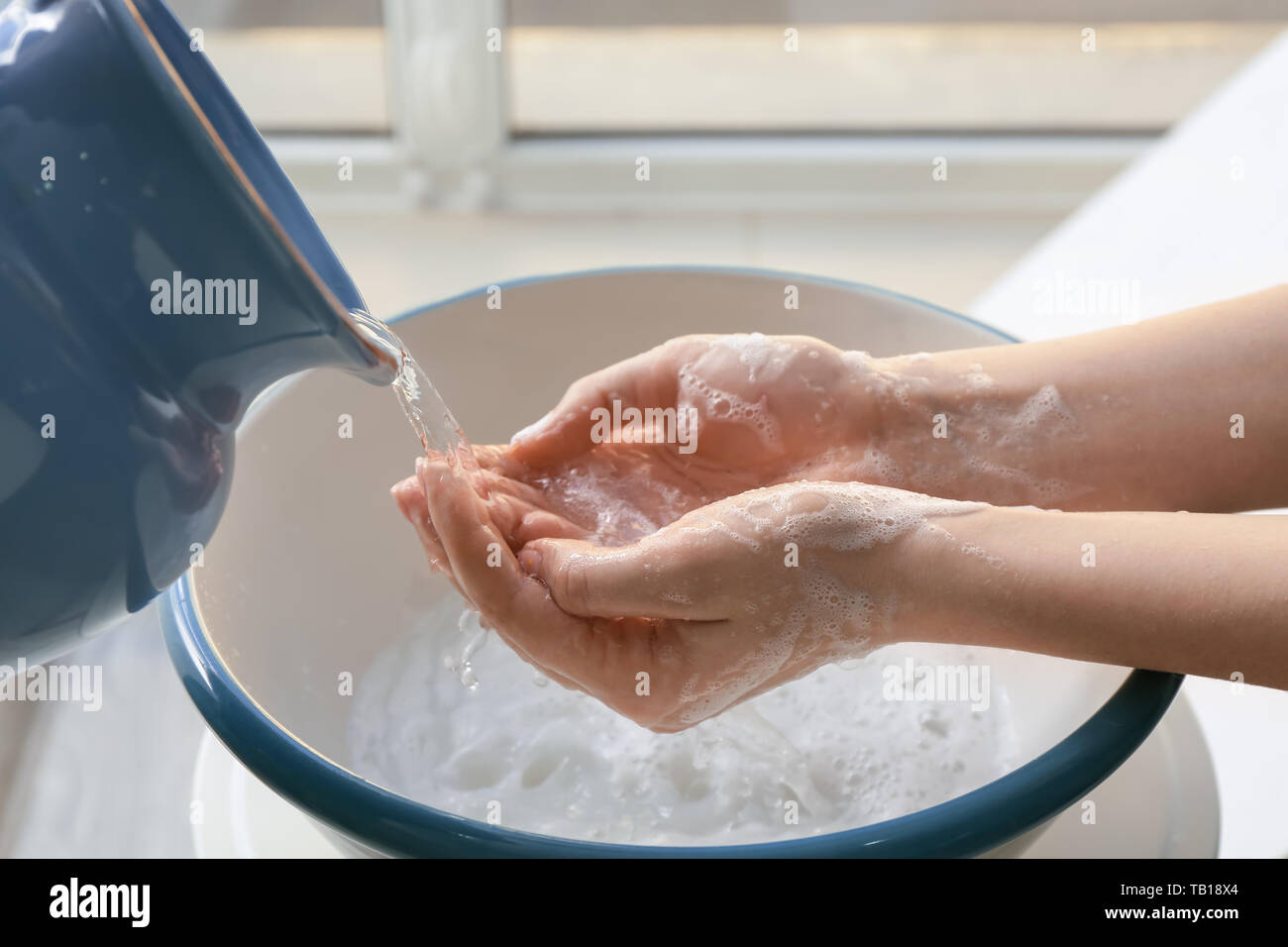 Woman washing hands in bowl Stock Photo - Alamy