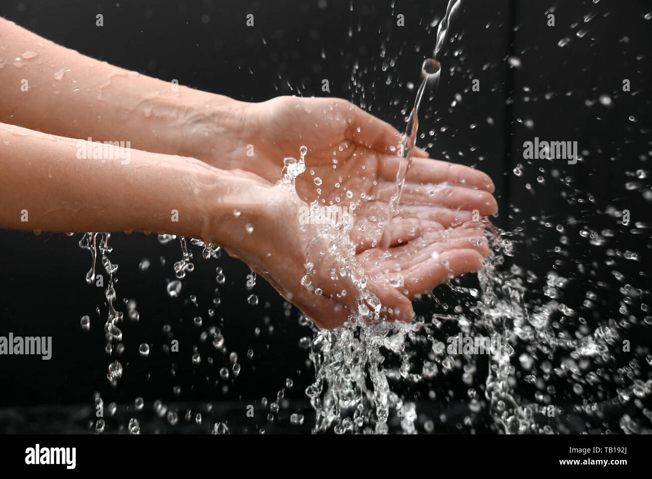 Woman washing hands on dark background Stock Photo - Alamy