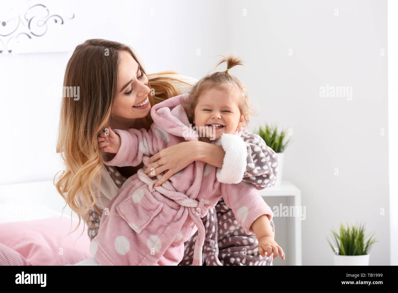 Young woman with her cute little daughter at home Stock Photo - Alamy