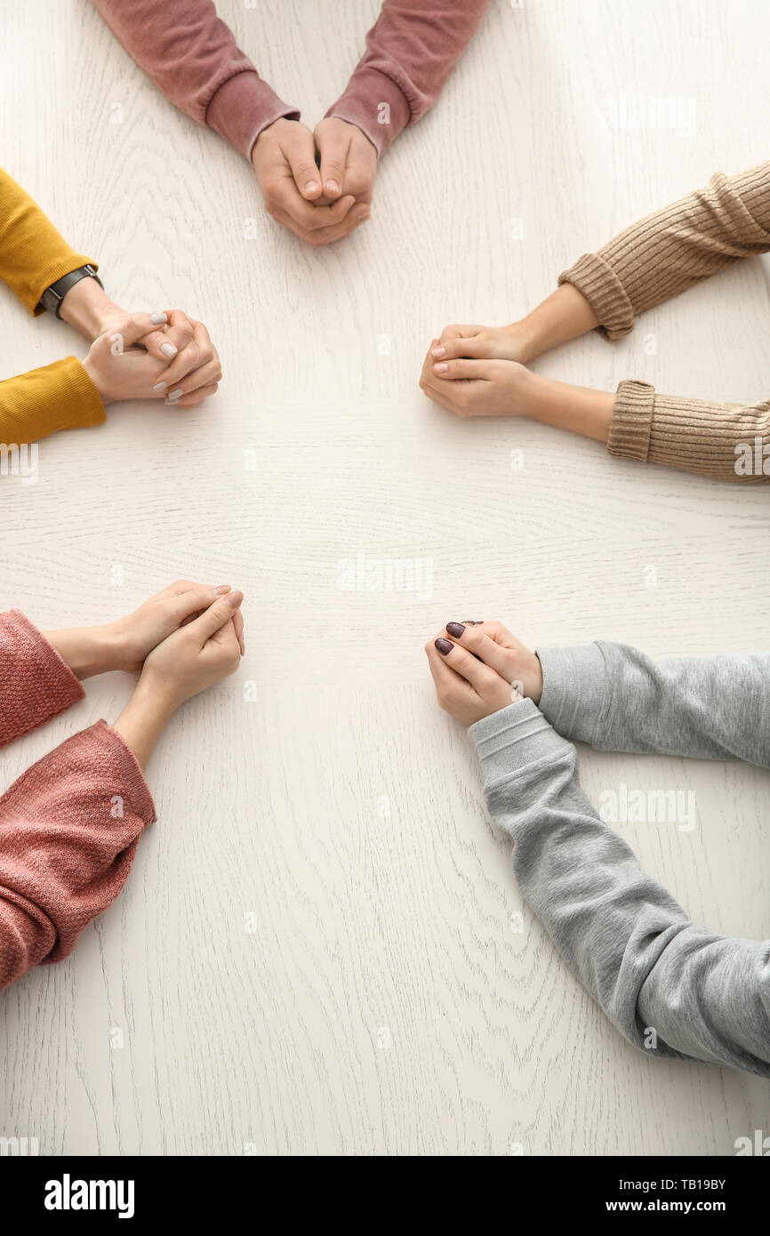 Group of people praying together at table Stock Photo - Alamy