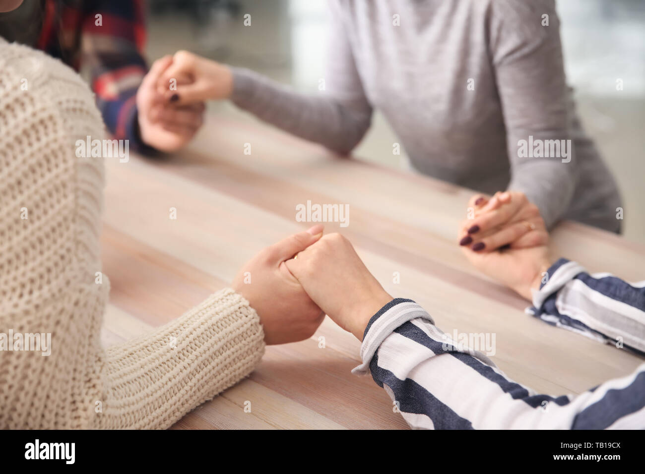 Group of people praying together at table Stock Photo - Alamy