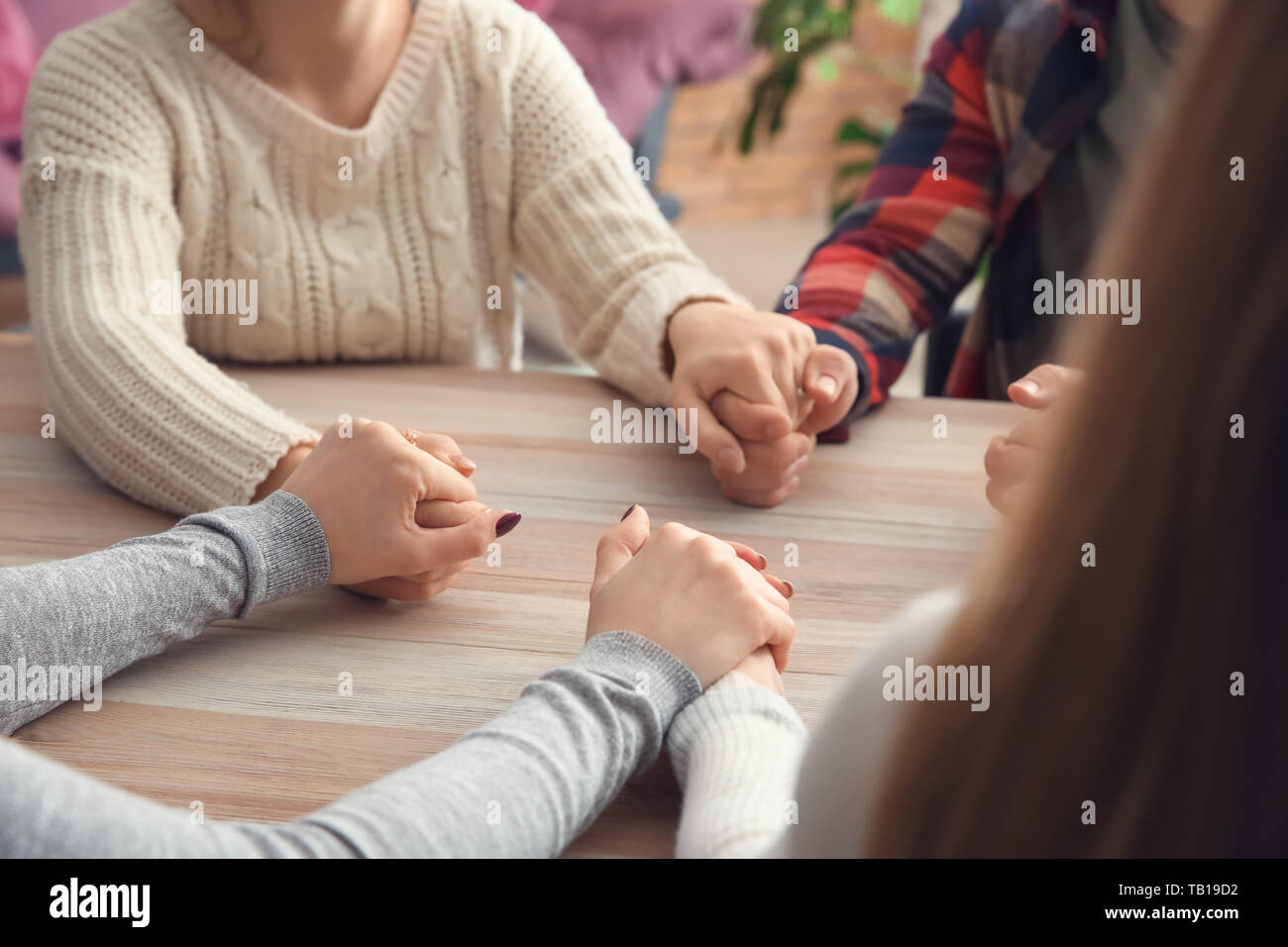 Group of people praying together at table Stock Photo - Alamy