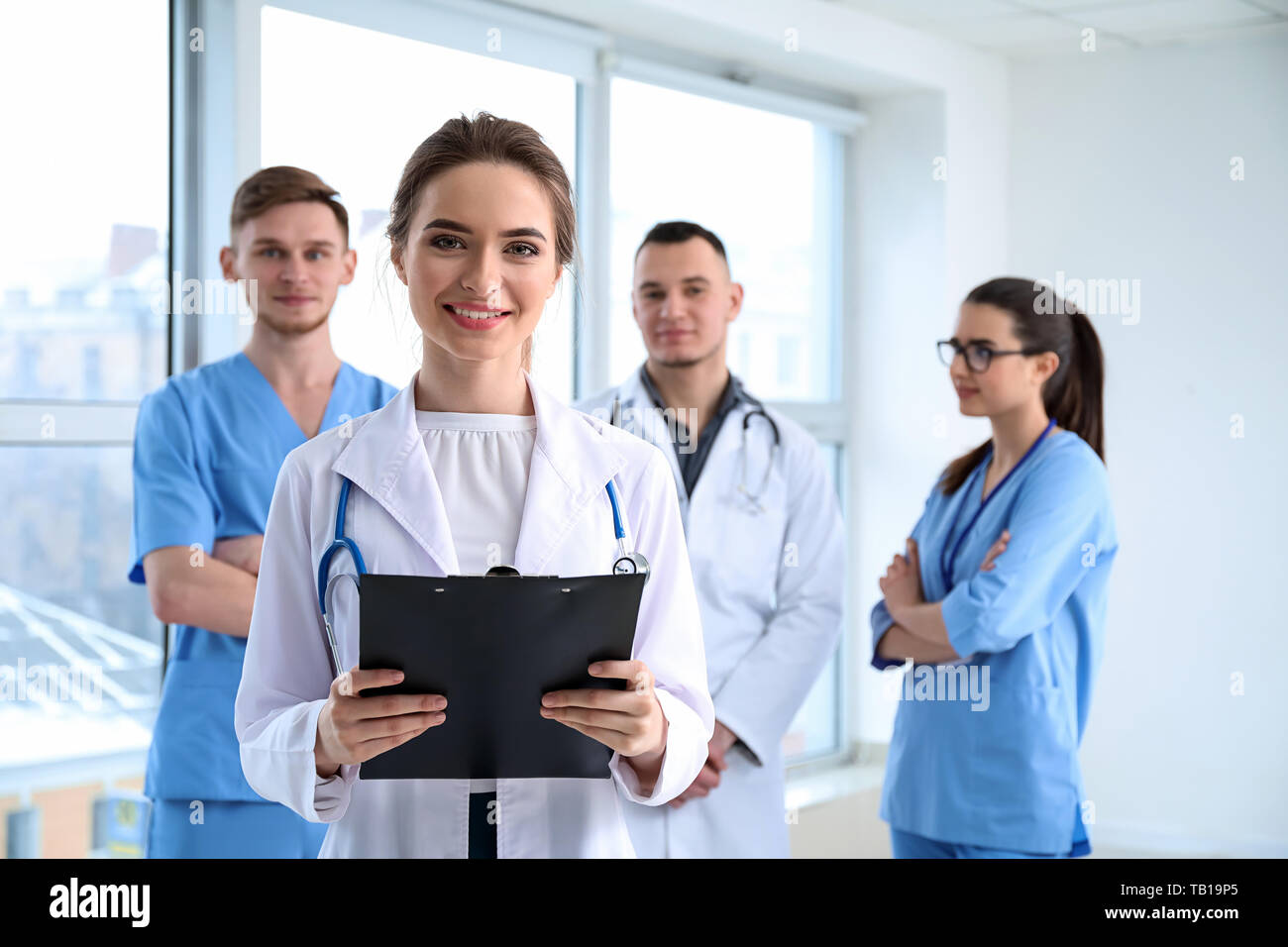 Female doctor and her colleagues in clinic Stock Photo - Alamy