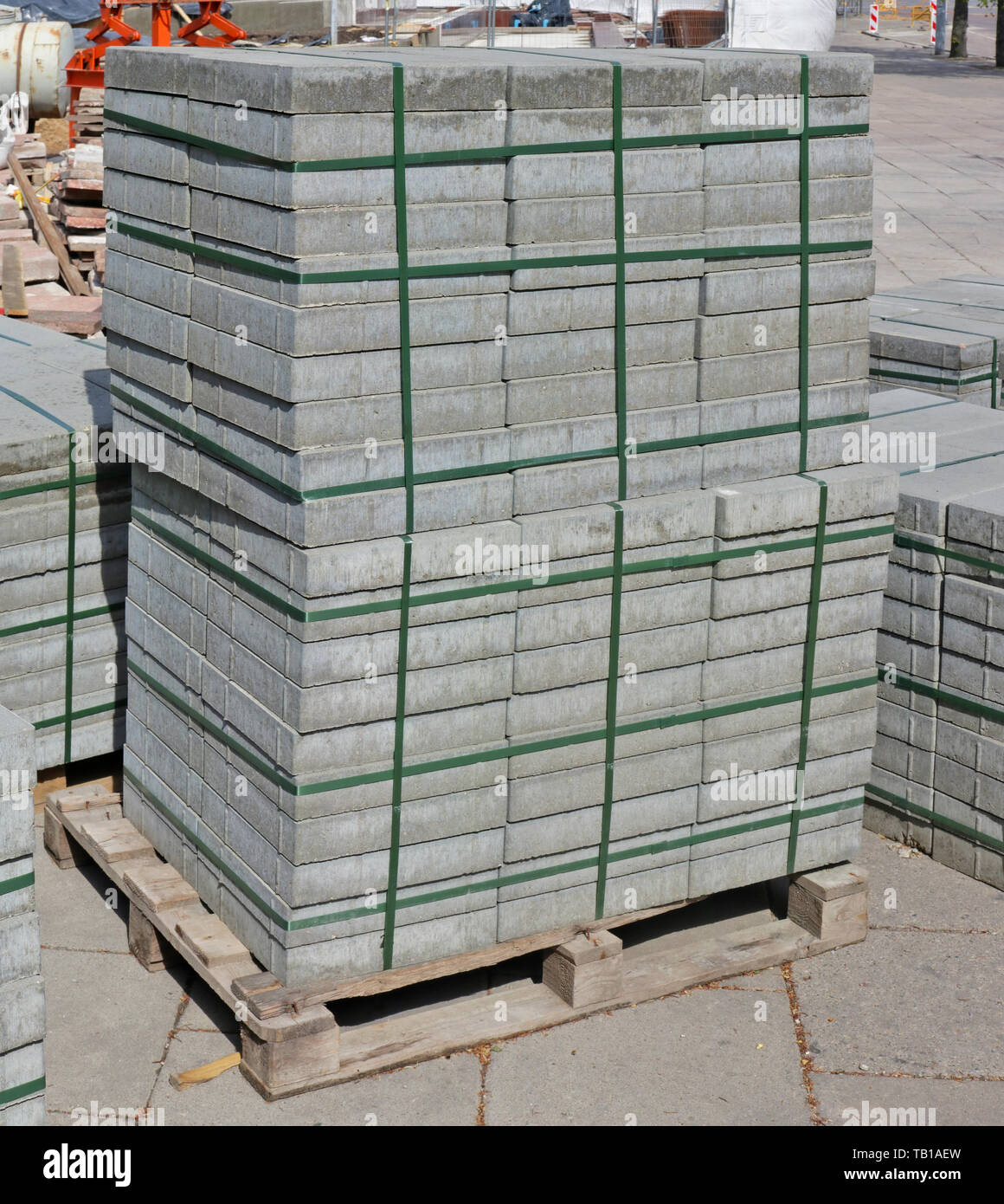Stacks of new concrete paving slabs on wooden pallet. Construction site ...