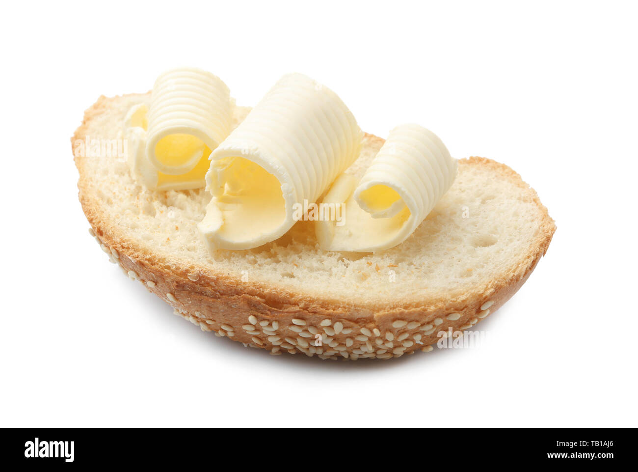 Slice of bread with butter curls on white background Stock Photo - Alamy