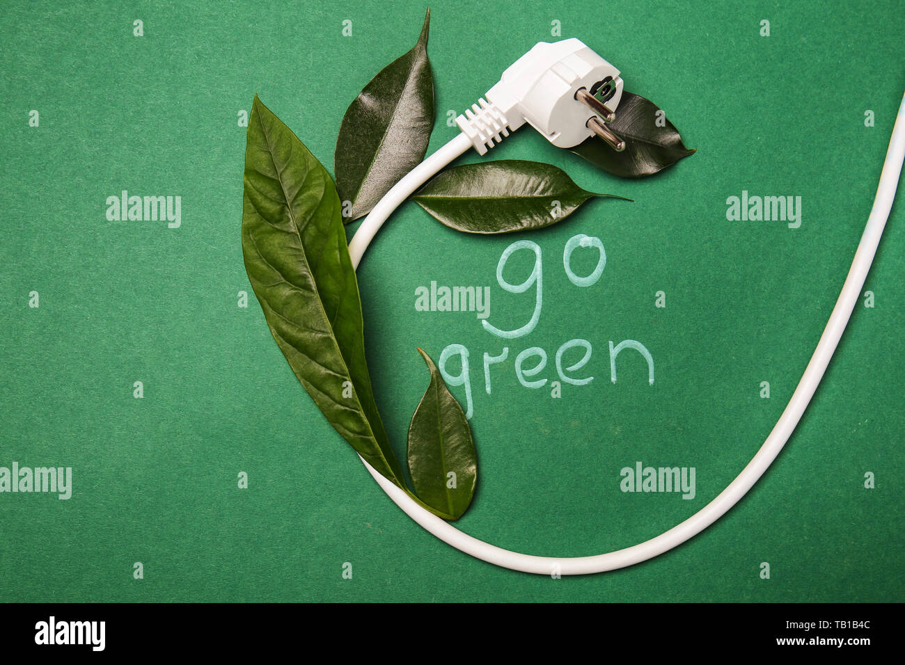 Electrical plug with leaves and text GO GREEN on color background Stock ...