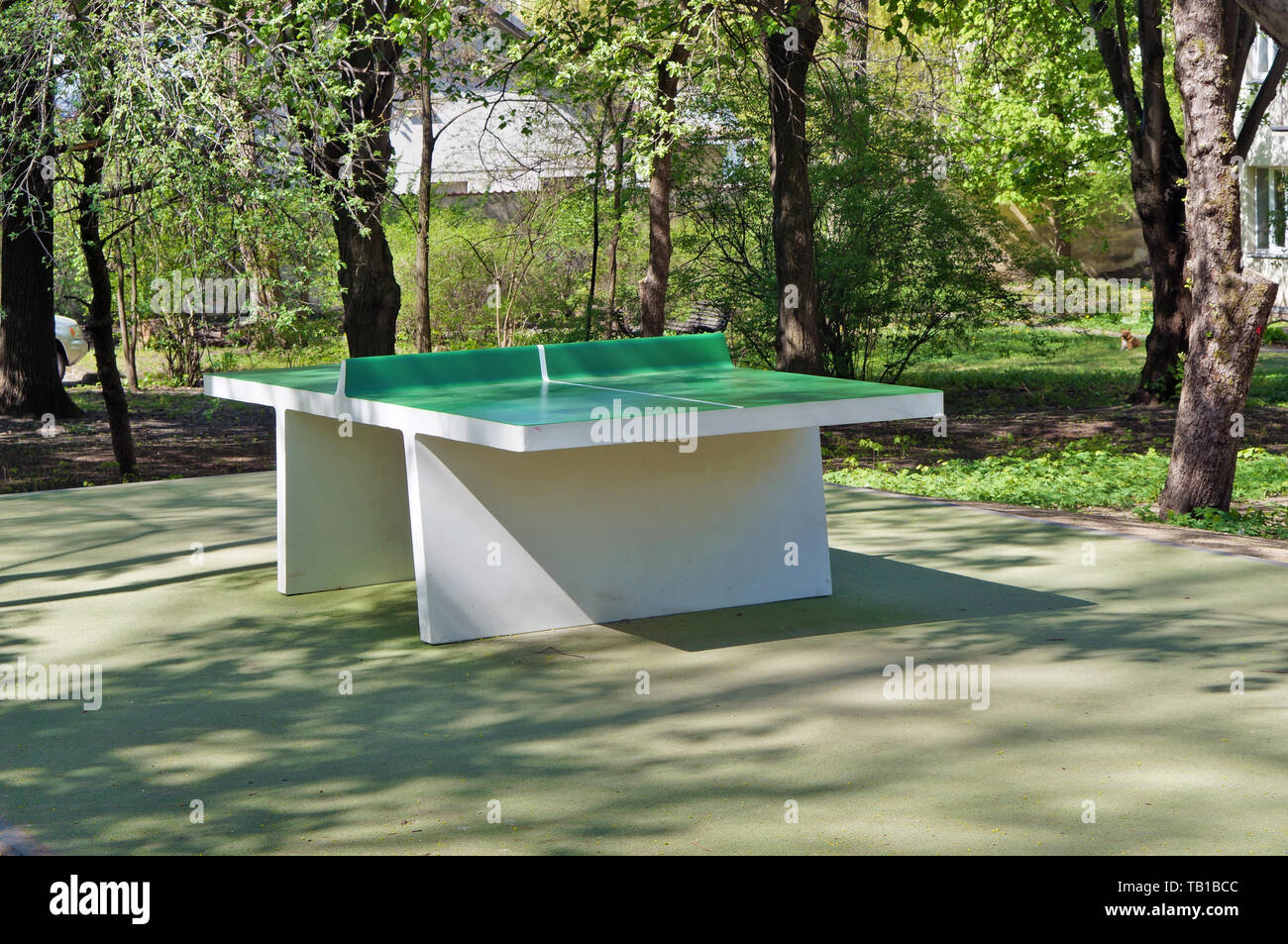Concrete new green ping pong table set in city public park. Sunny April ...
