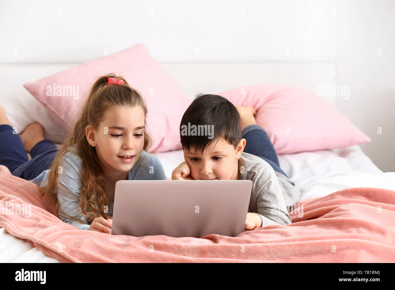Cute little children with laptop watching cartoons at home Stock Photo ...