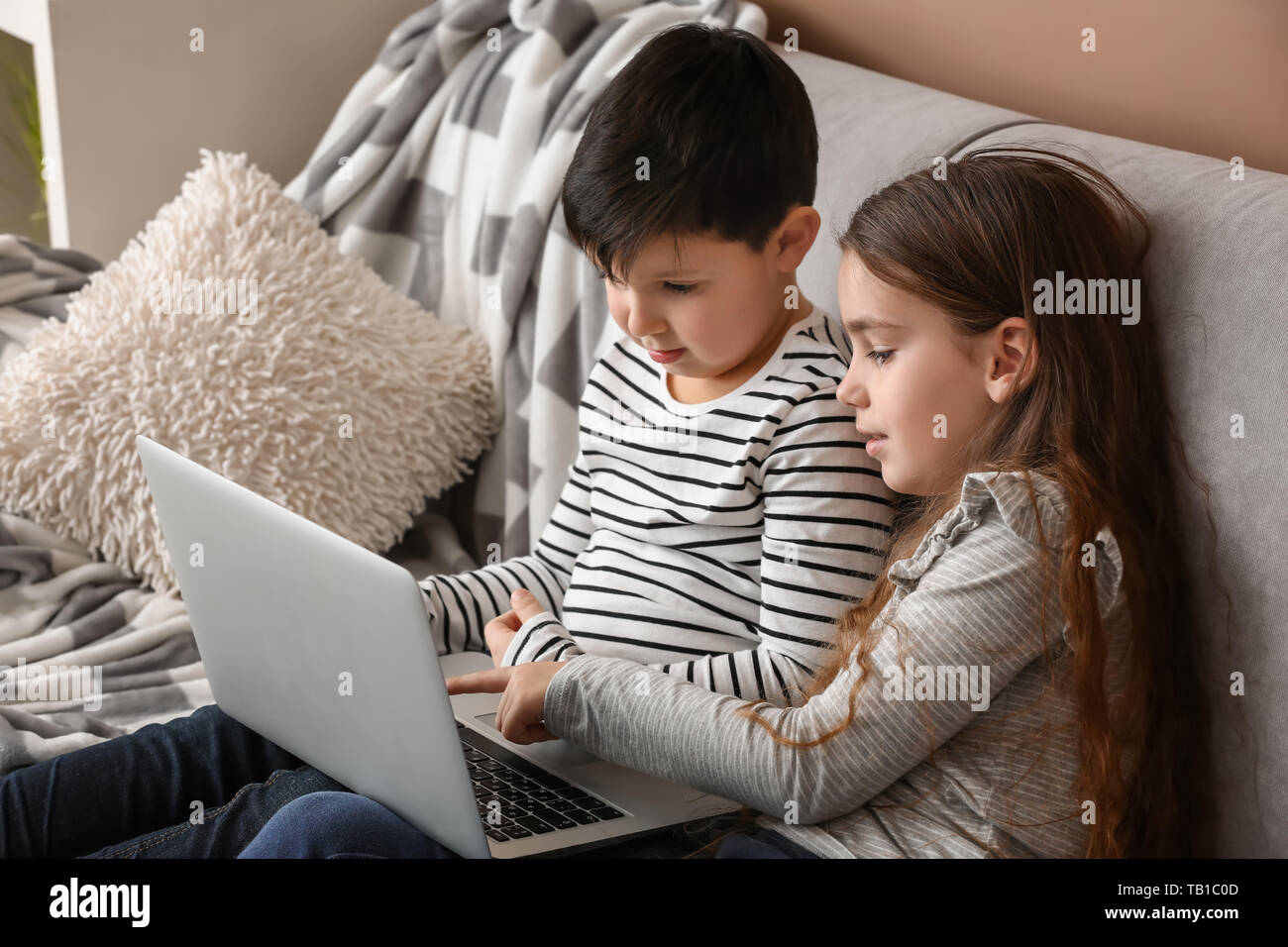 Cute little children with laptop watching cartoons at home Stock Photo ...
