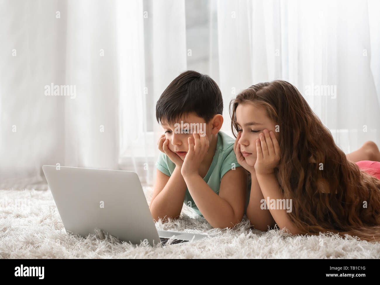 Cute little children with laptop watching cartoons at home Stock Photo ...