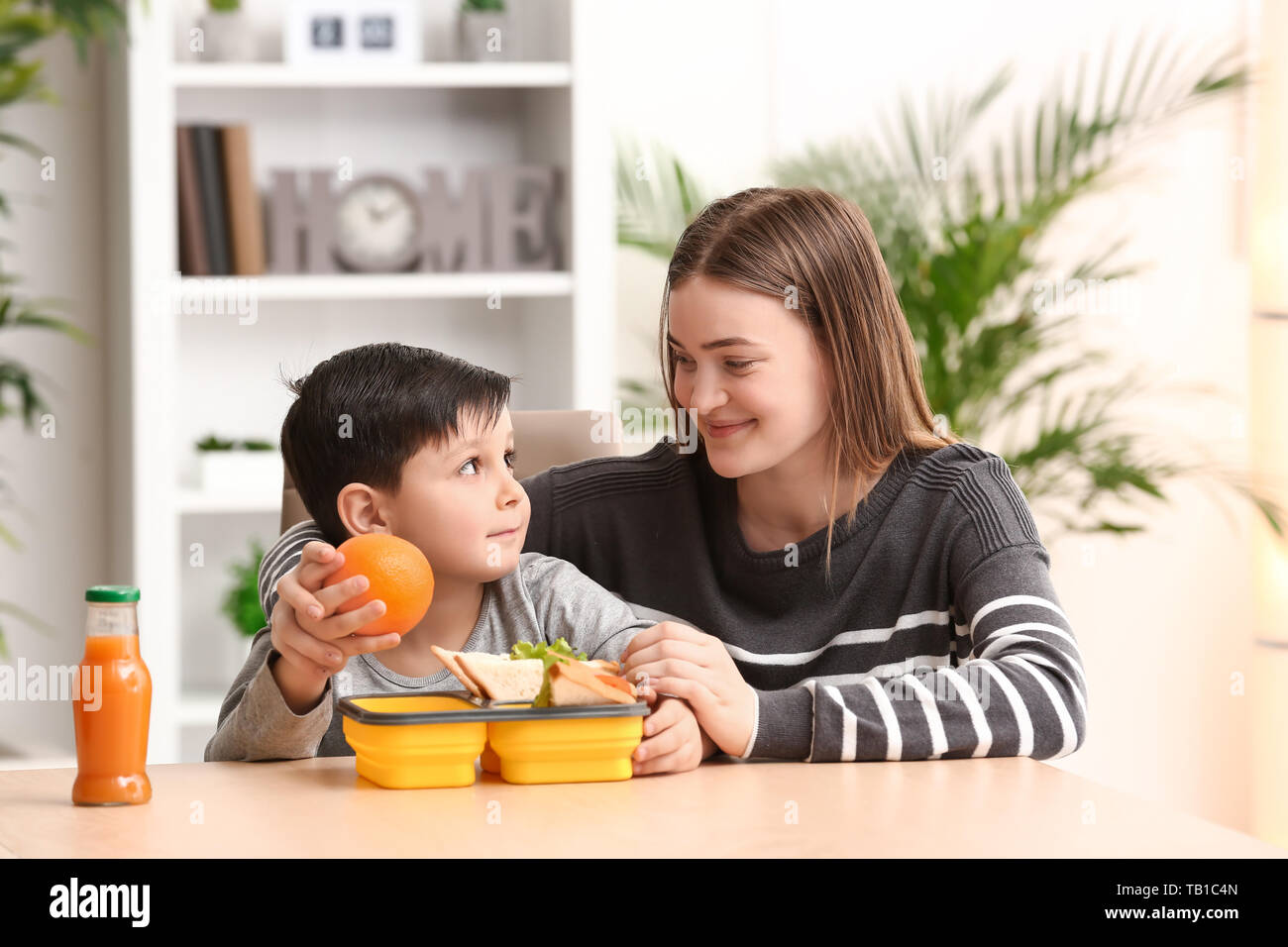Mother packing school lunch for her little son at home Stock Photo - Alamy