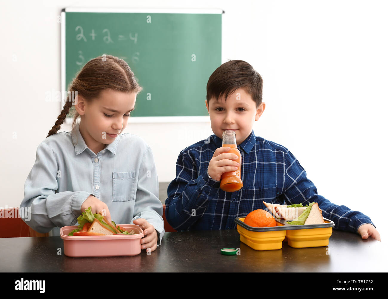 Little children having lunch in classroom Stock Photo - Alamy