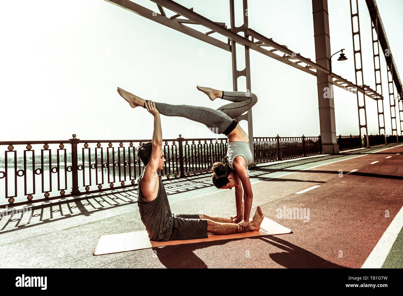 Strong girl doing a handstand on the bridge Stock Photo - Alamy