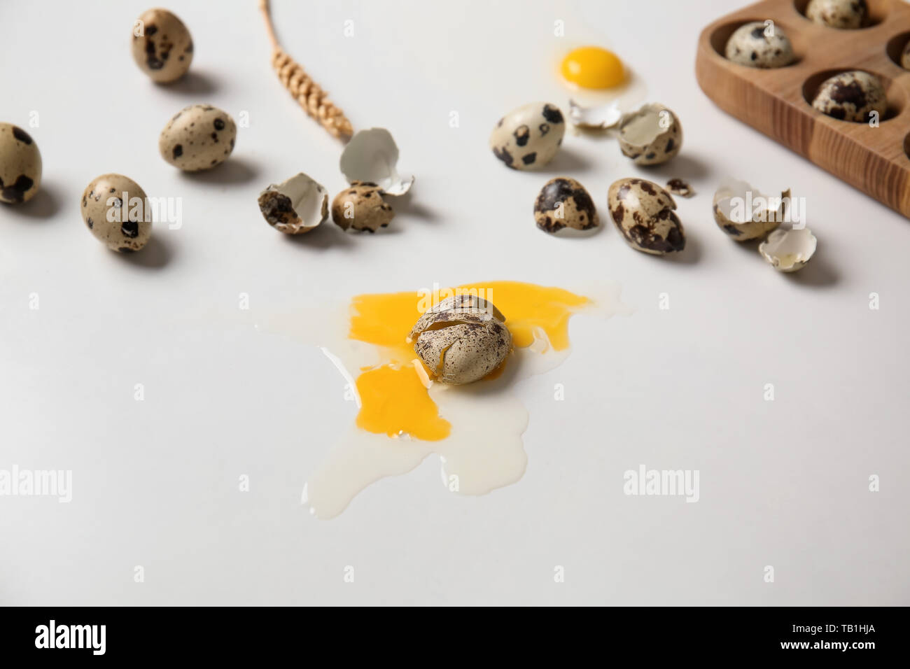 Broken raw quail eggs on white background Stock Photo - Alamy