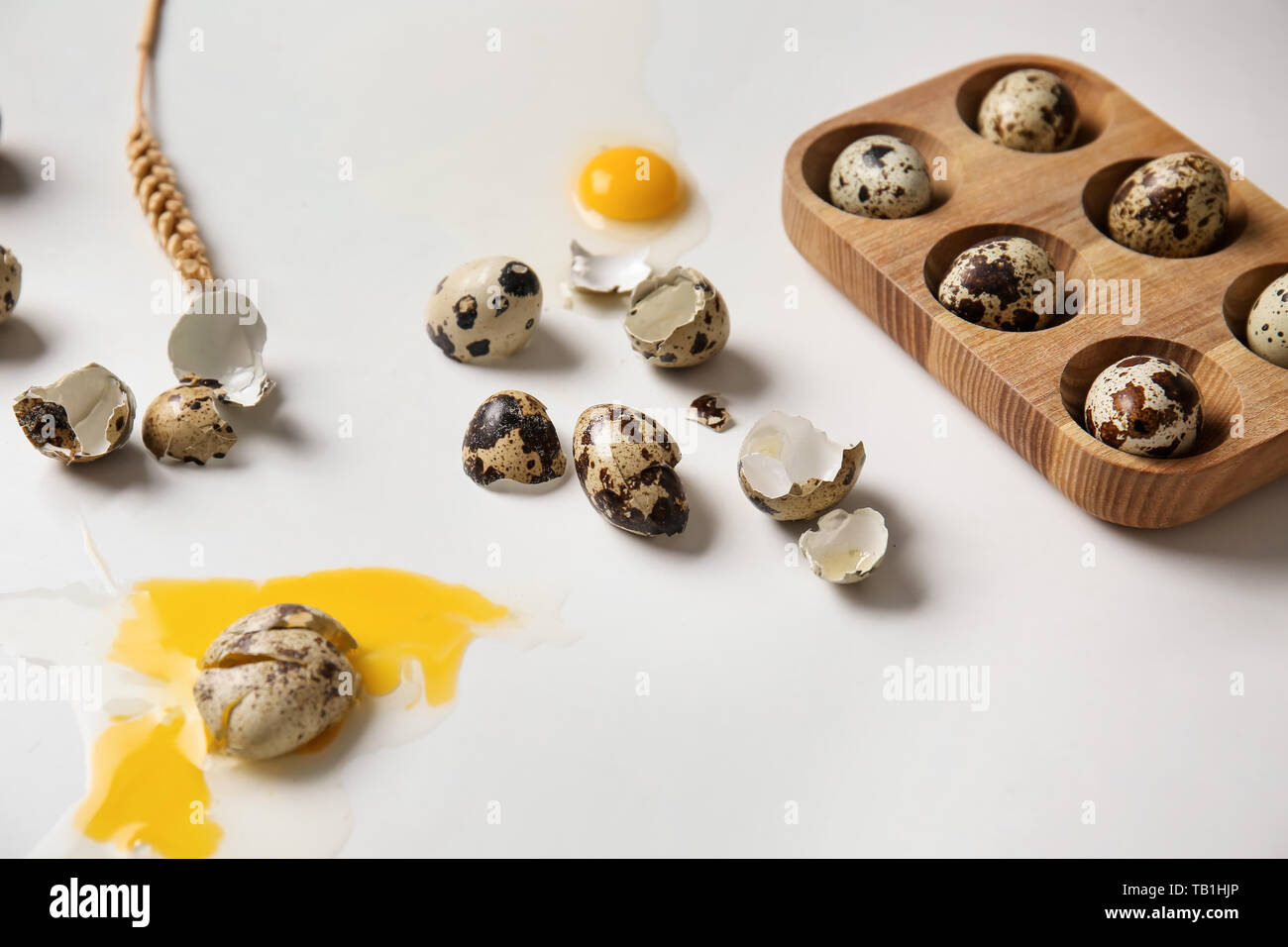 Broken raw quail eggs on white background Stock Photo - Alamy