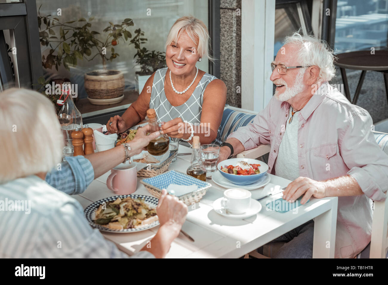 Happy blonde couple sitting opposite their friends Stock Photo - Alamy