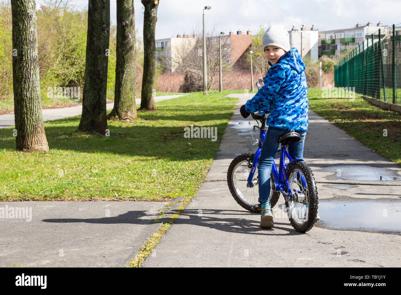 Boy child on bike stopping to look back Stock Photo - Alamy