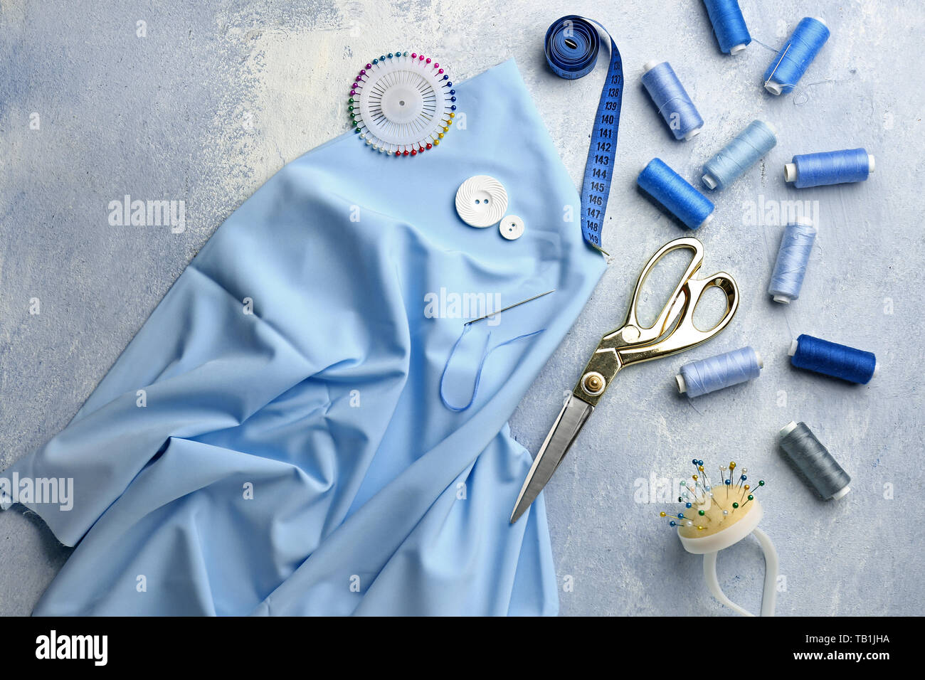 Cloth with tailor's accessories on light background Stock Photo - Alamy