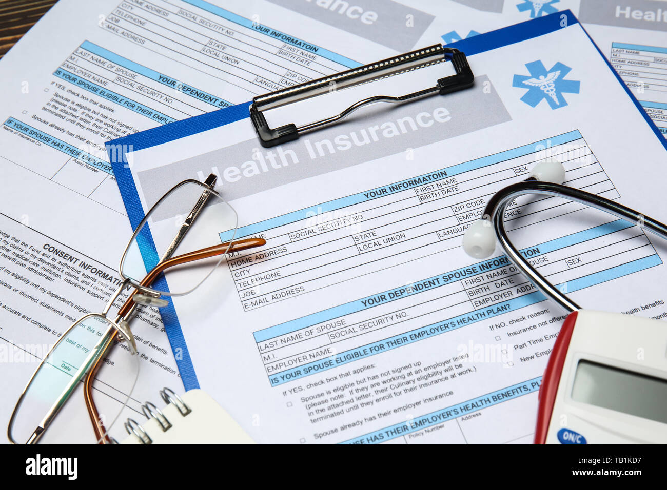 Health insurance forms with eyeglasses and stethoscope on table Stock ...