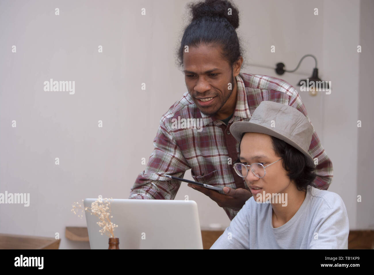 two young creative man discuss with laptop and tablet, young asian and ...