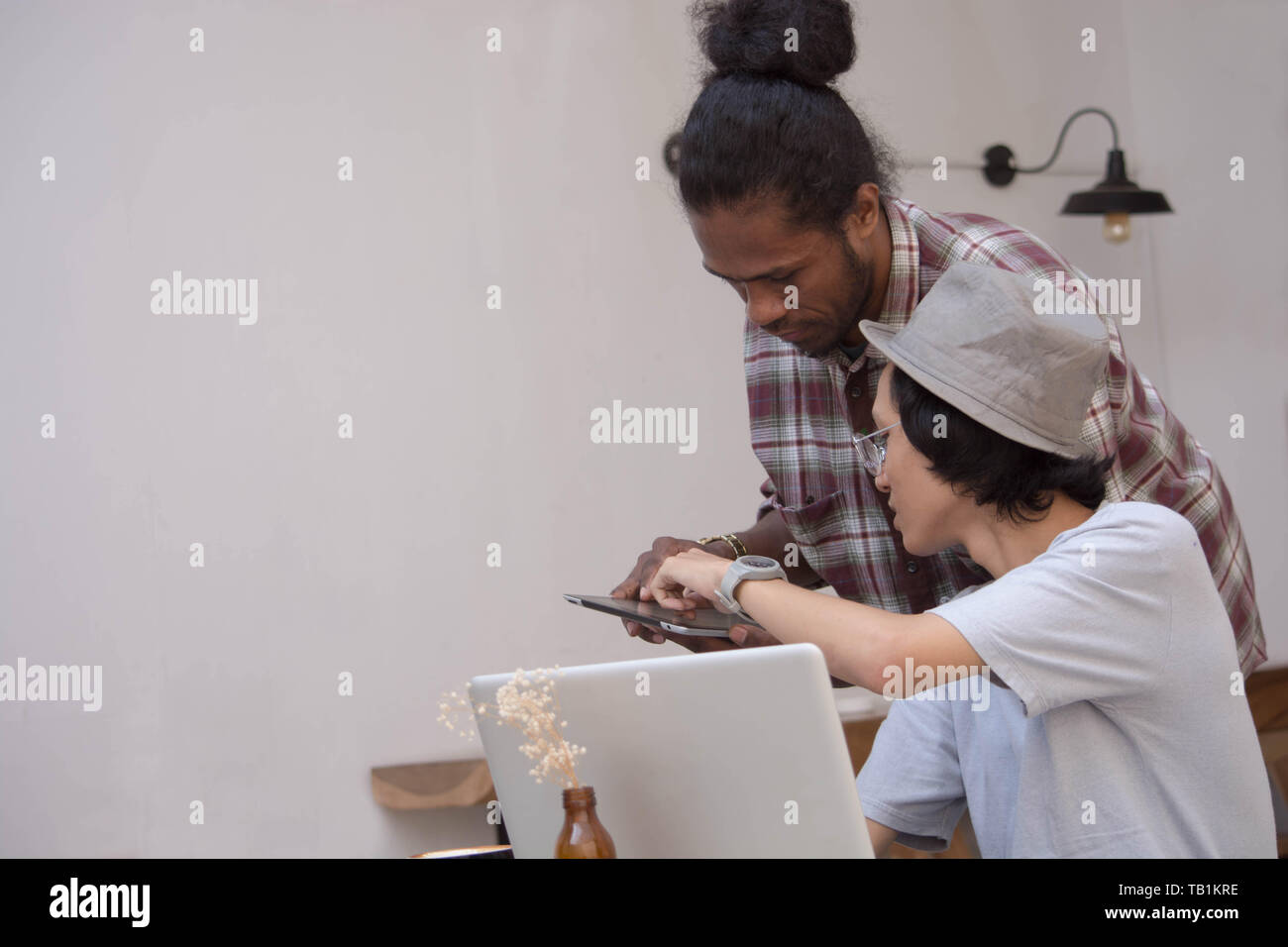 two young creative man discuss with laptop and tablet, young asian and ...