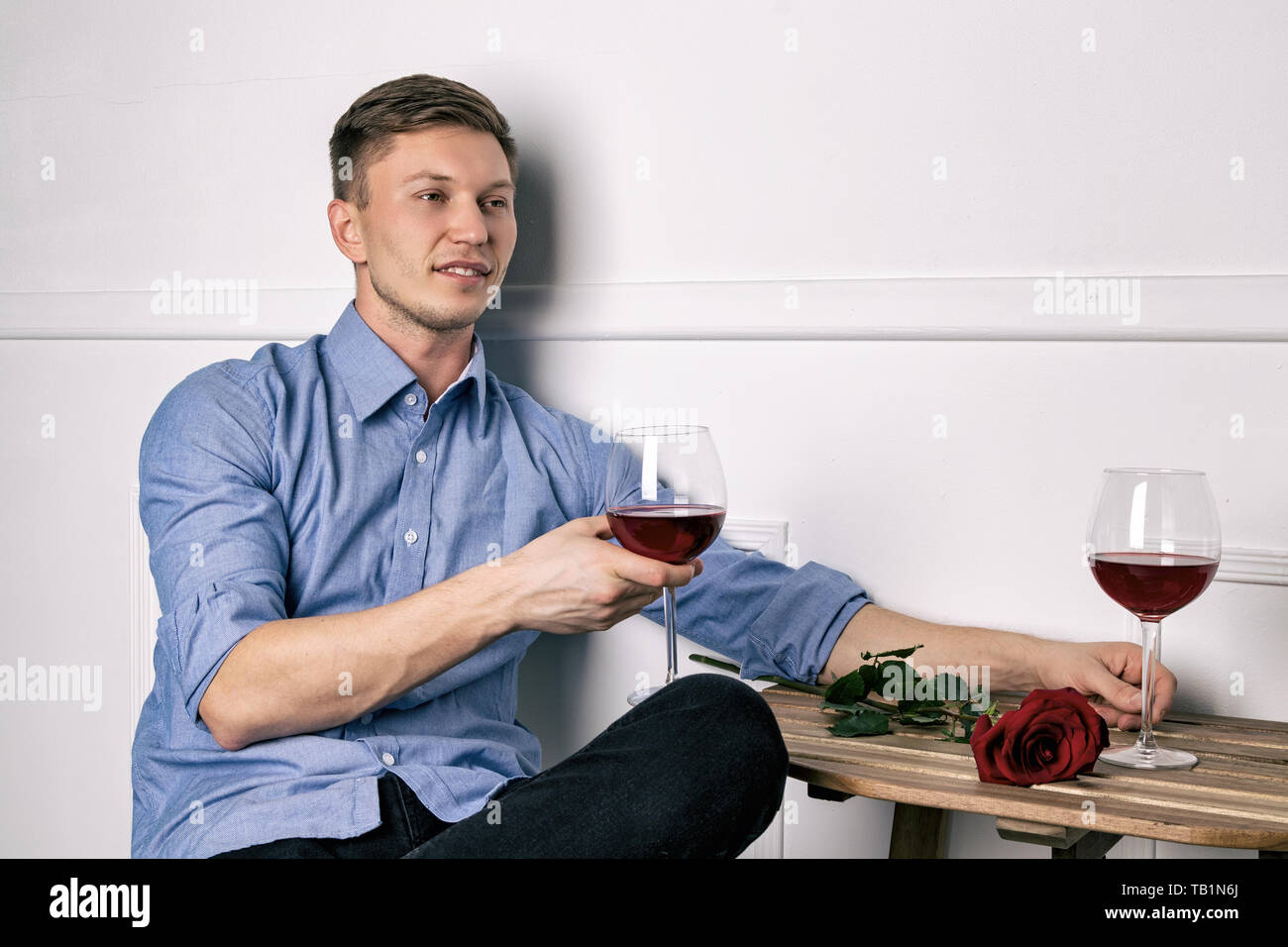 Young handsome man sitting by table in cafe Stock Photo - Alamy